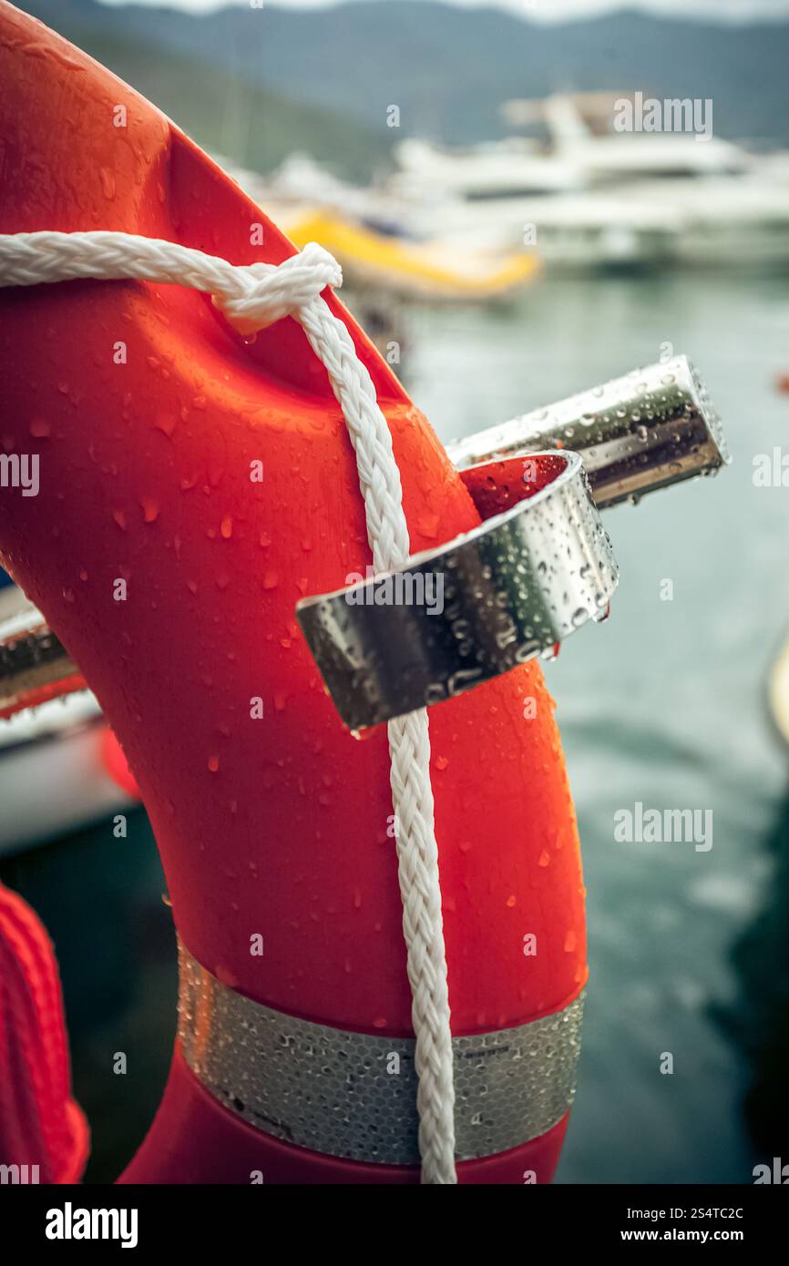 Closeup photo of red lifebuoy with rope against sea port Stock Photo ...