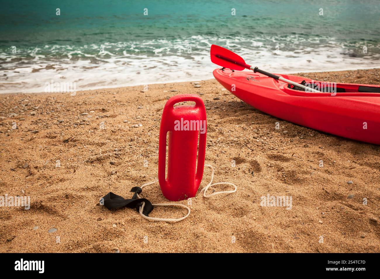 Closeup photo of life saving buoy and lifeguard kayak on sand beach ...
