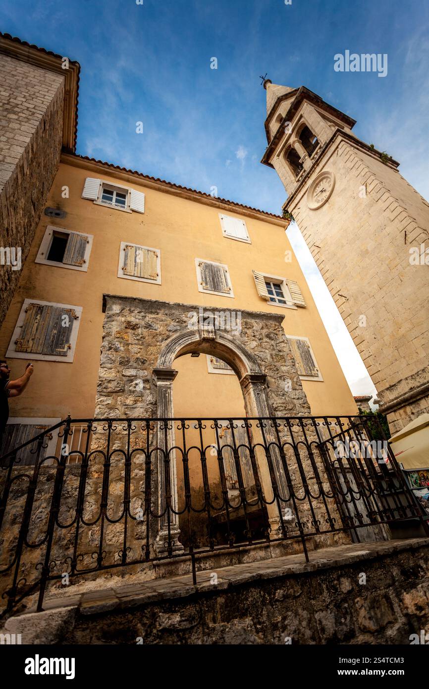 Ancient stone gates and high tower on street of Budva, Montenegro Stock ...
