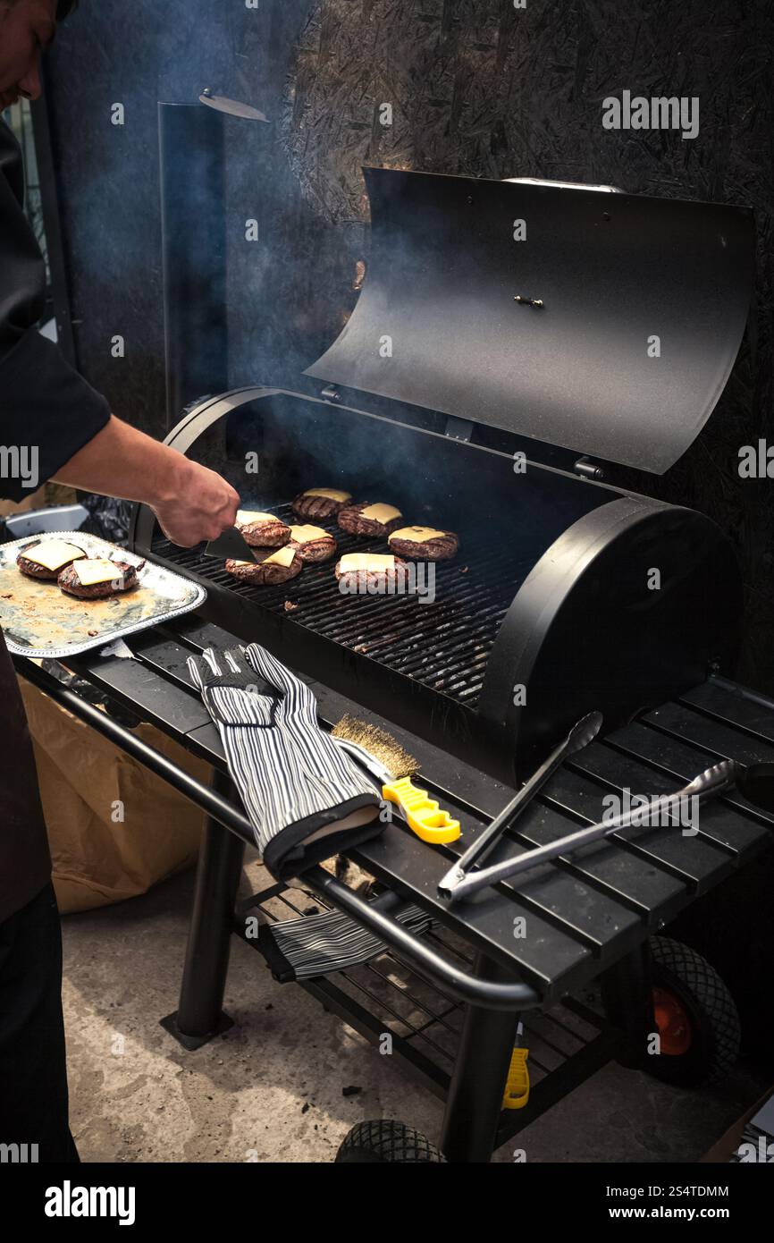 Photo of man cooking marbled meat on barbecue for burgers Stock Photo ...