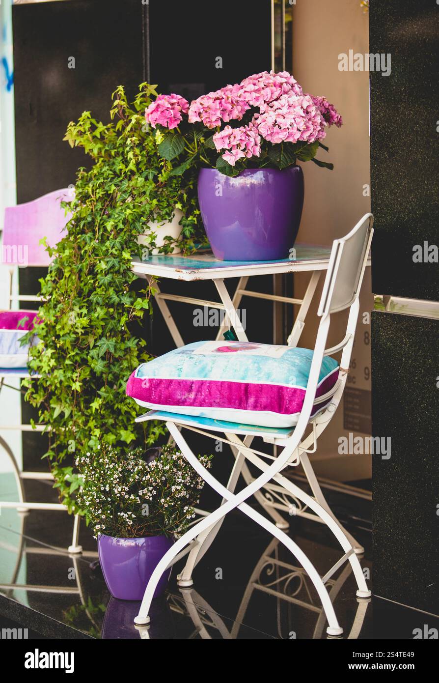 Decorative metal chair, garden table and plants in pots Stock Photo - Alamy