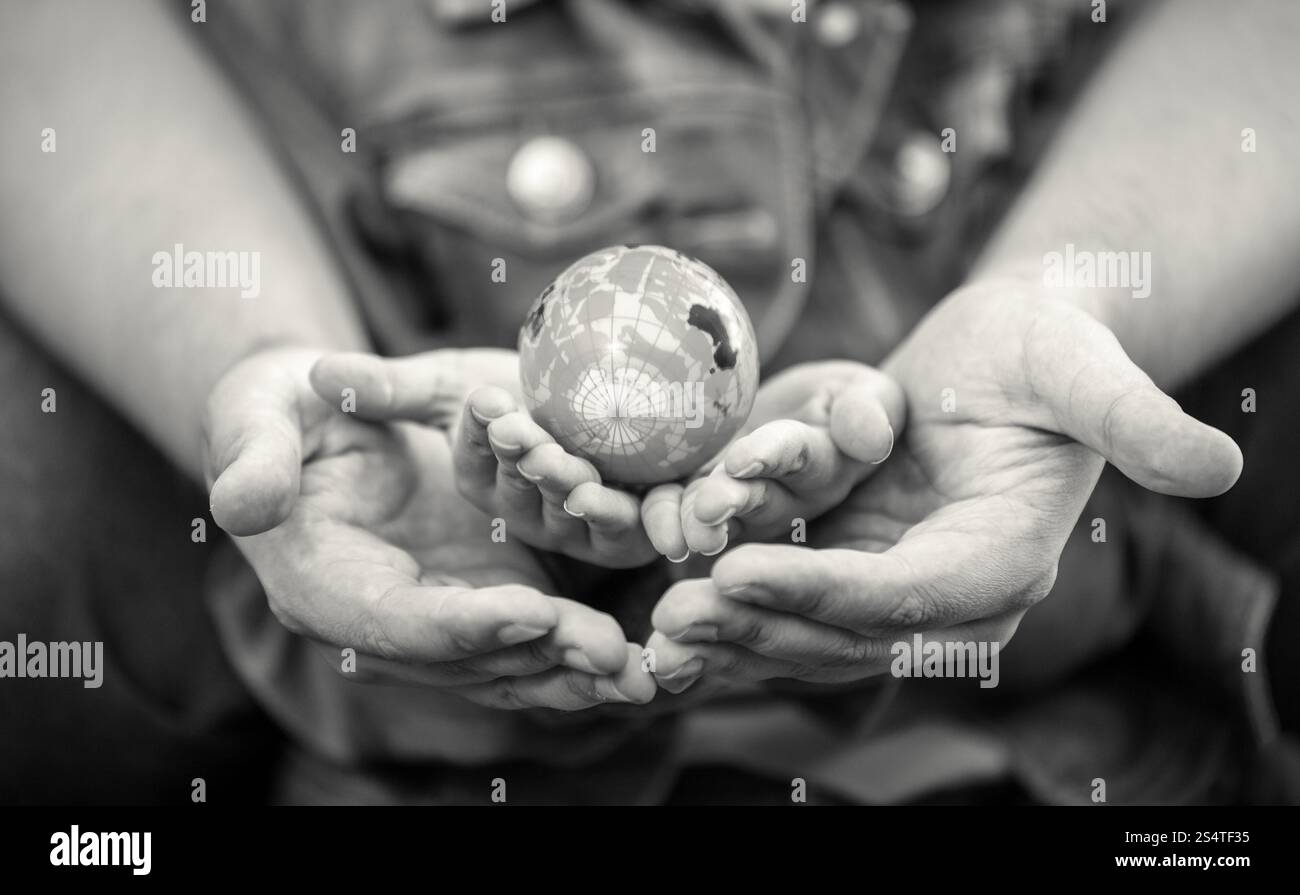 Black and white shot of man protecting girls hands holding globe Stock ...