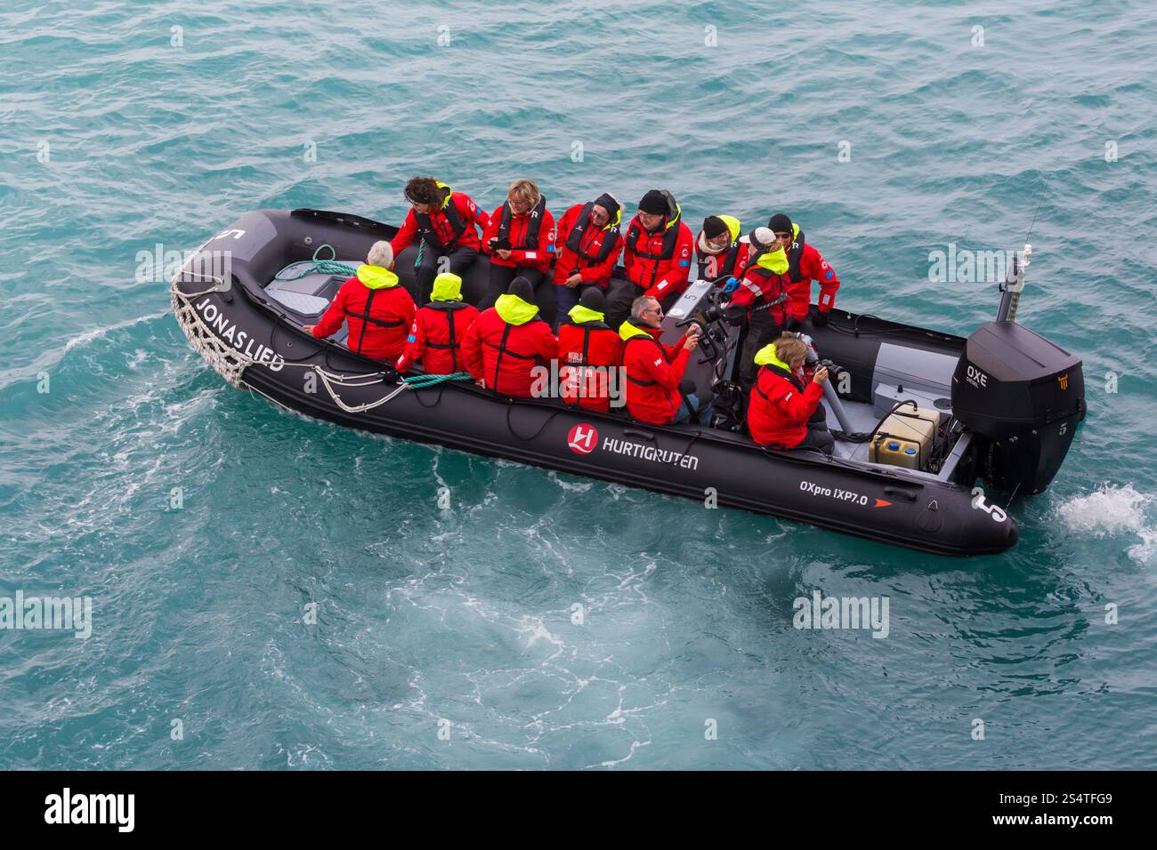 Tourists on zodiac being taken ashore at Kvanefjord, Greenland in July ...