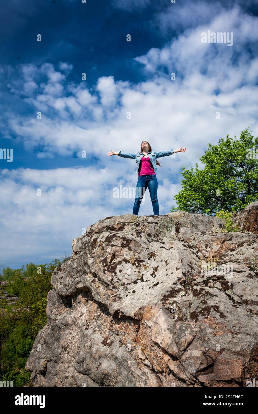 Outdoor photo of beautiful woman standing on top of high cliff with ...