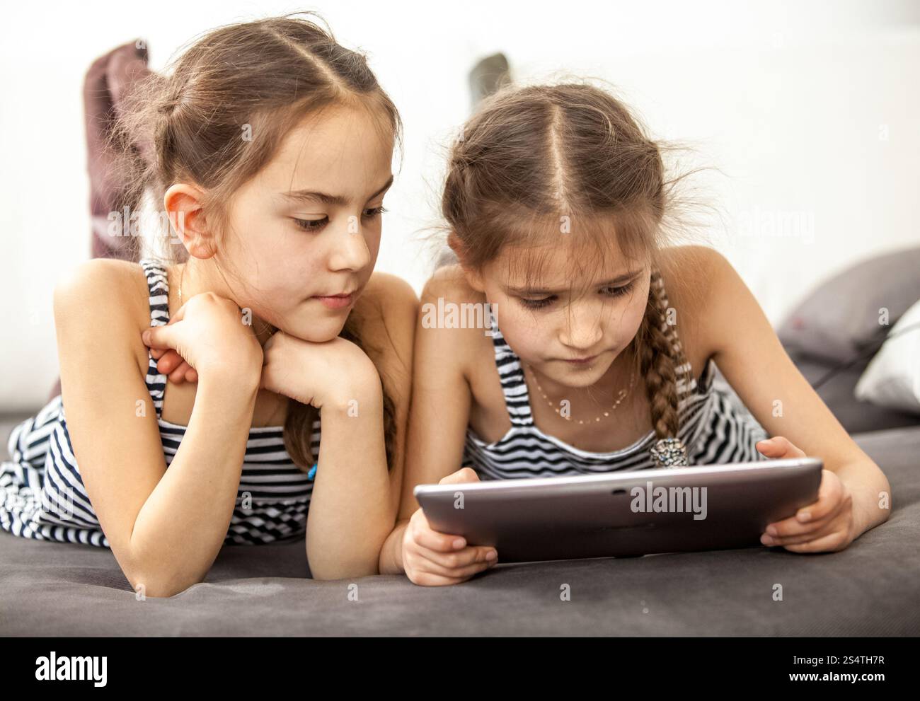 Portrait of concentrated young girls using digital tablet Stock Photo ...
