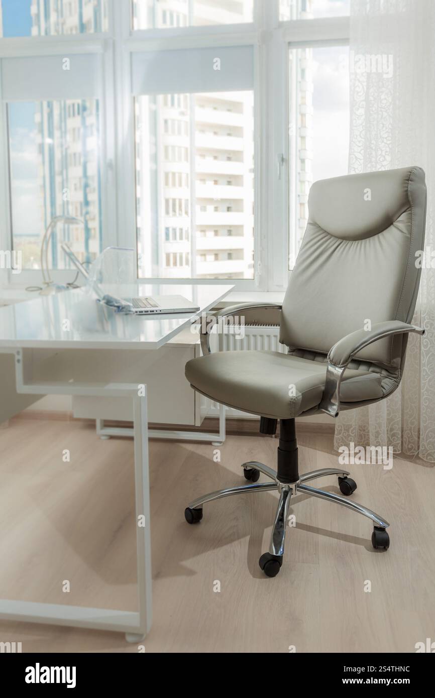 Interior photo of office leather chair behind white working table Stock ...