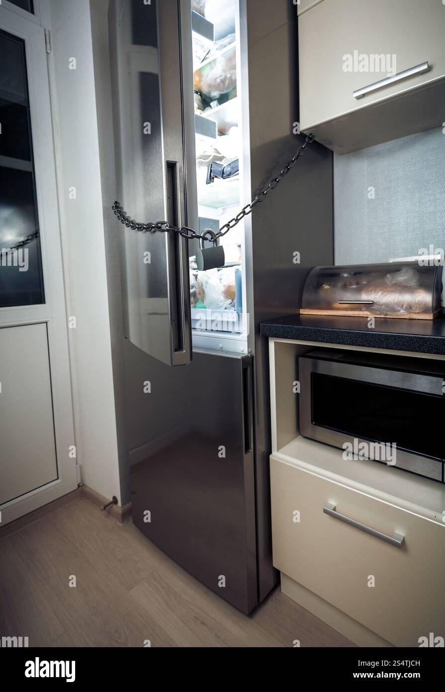 Photo of refrigerator on kitchen locked by chain Stock Photo - Alamy