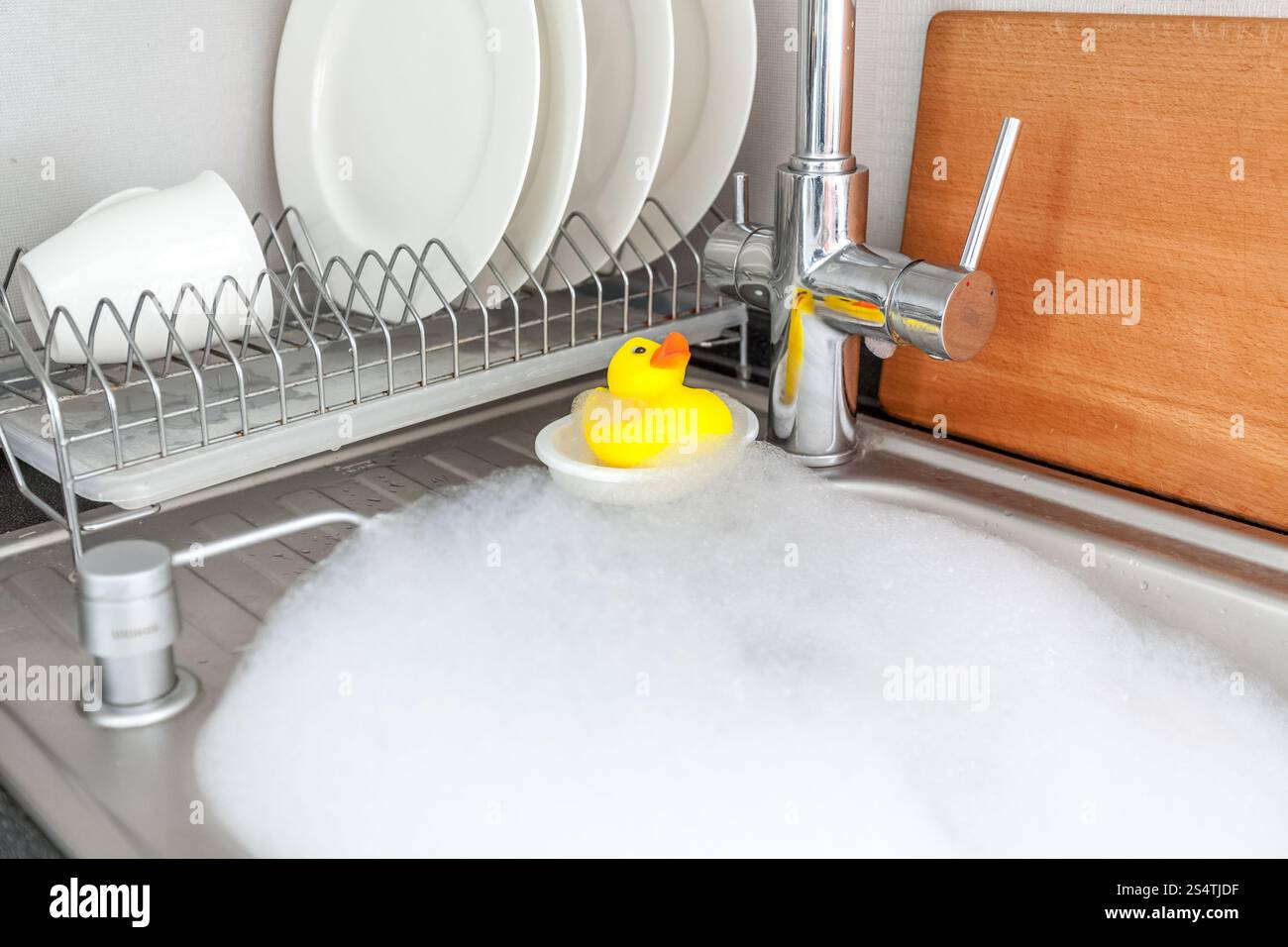 Photo of yellow rubber duck in foamy kitchen sink Stock Photo - Alamy