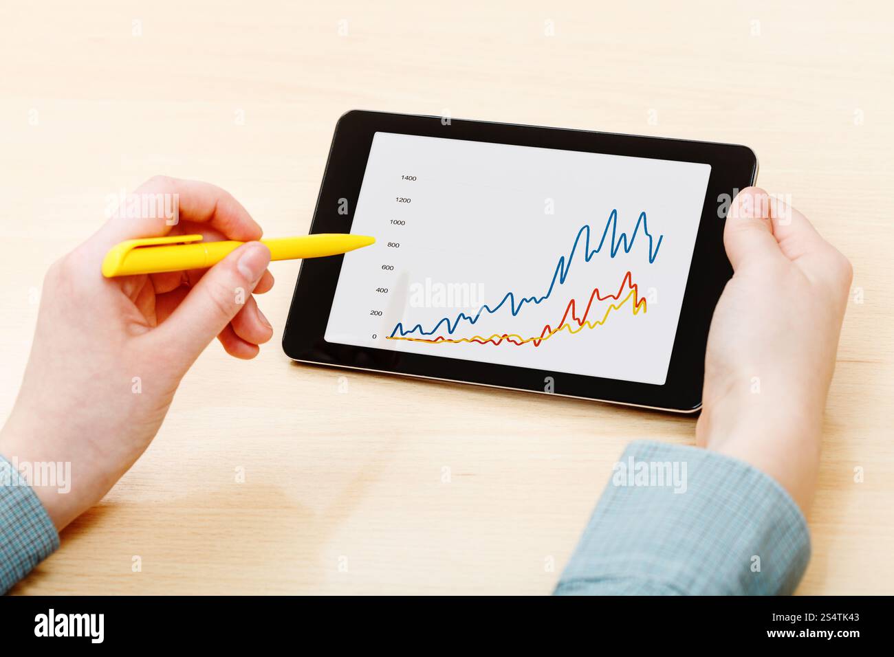businessman touches by pen of tablet PC with graph on screen at office ...