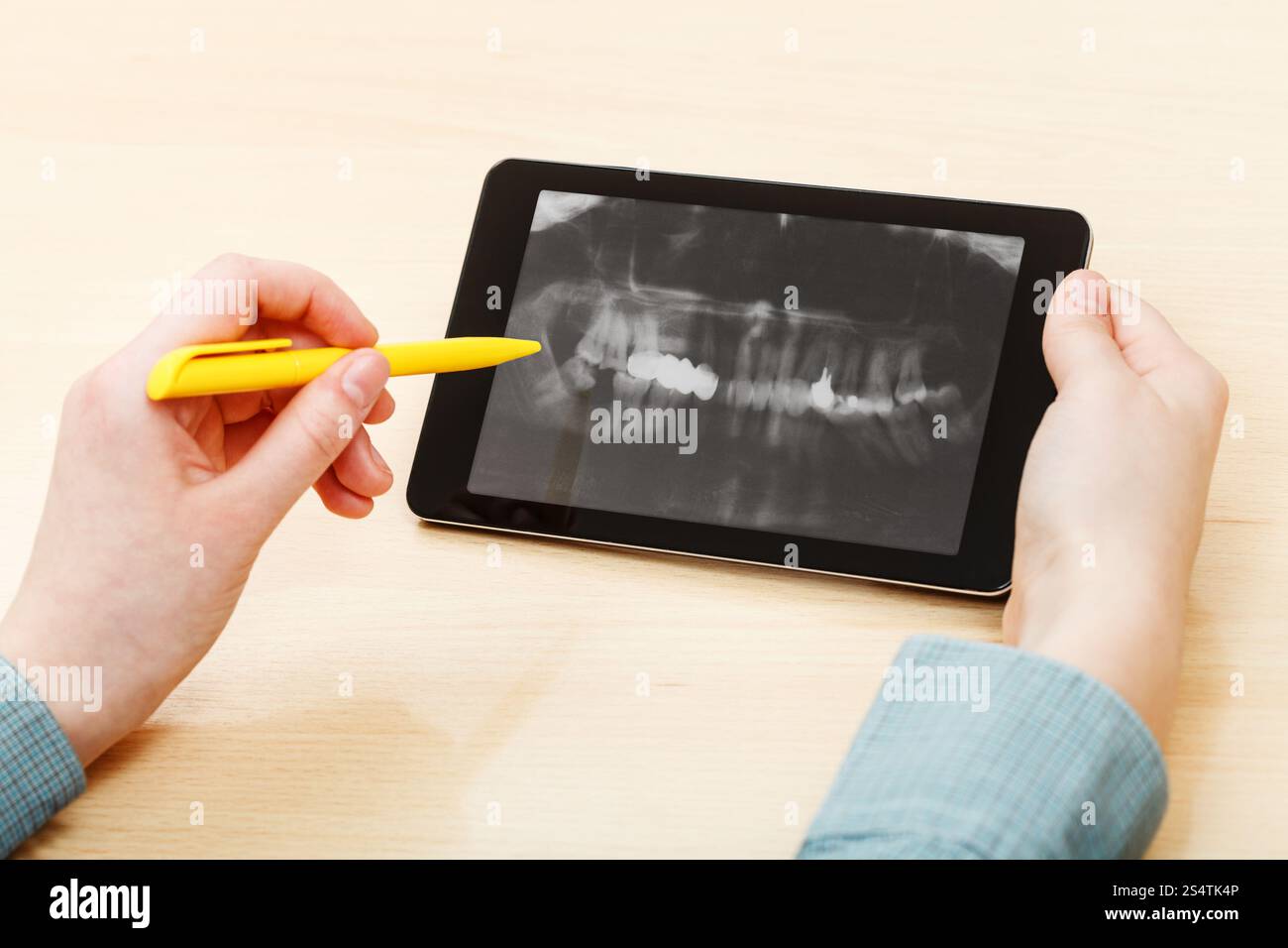 student analyzes X-ray picture of human jaws on screen on tablet pc ...