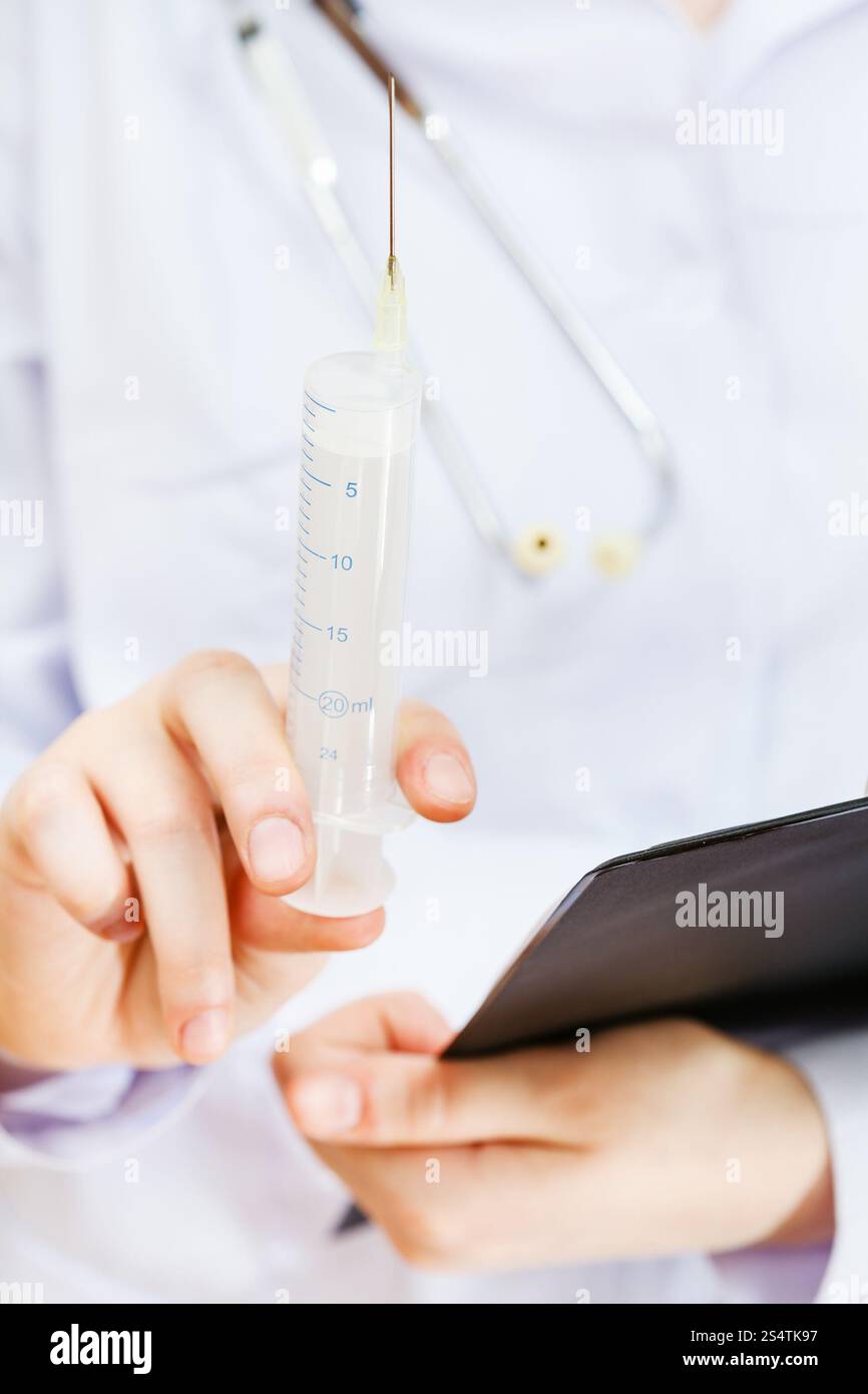nurse holds syringe and clipboard close up Stock Photo - Alamy