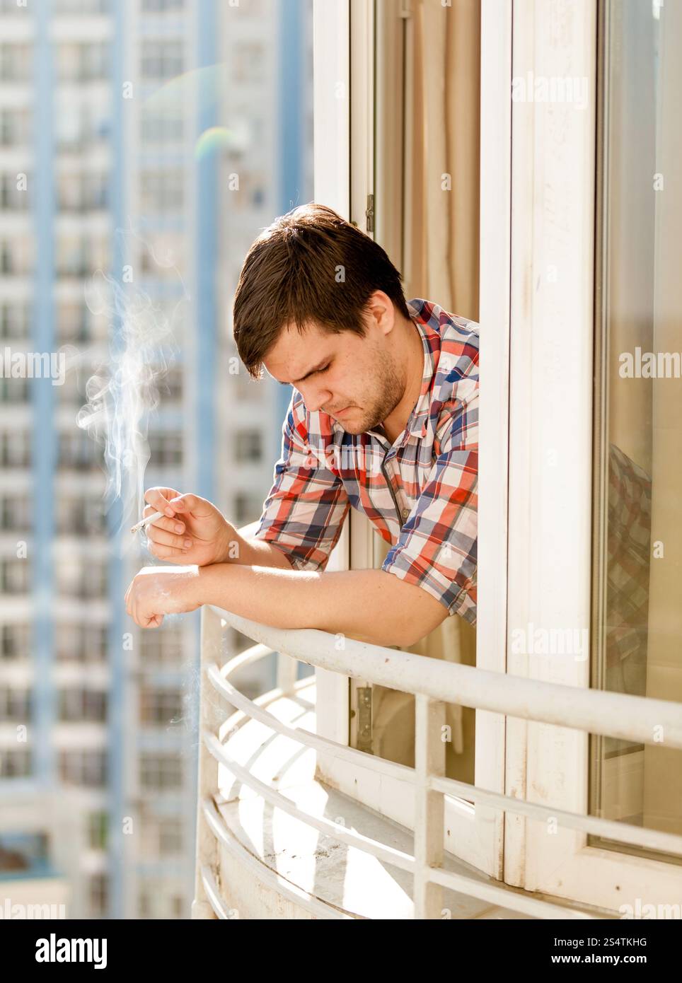 Closeup photo of depressed man smoking cigarette out of window Stock ...