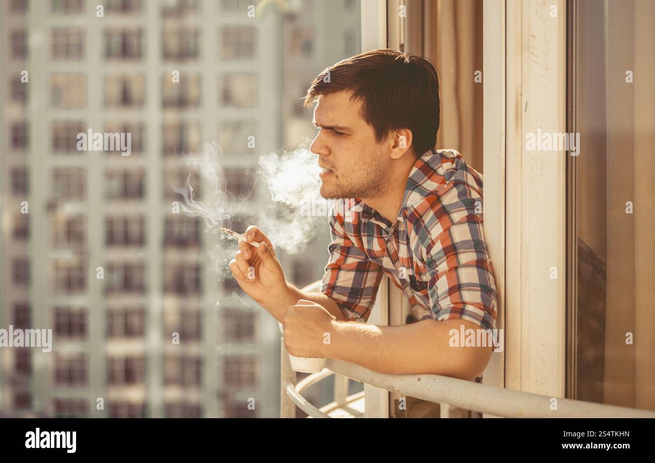 Toned portrait of hipster guy smoking cigarette and drinking coffee ...
