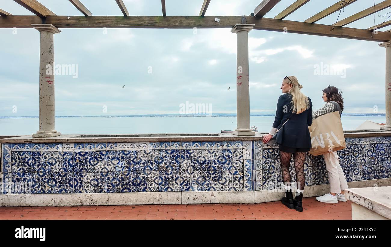 Tourists enjoy the stunning panoramic views of Lisbon's rooftops and ...
