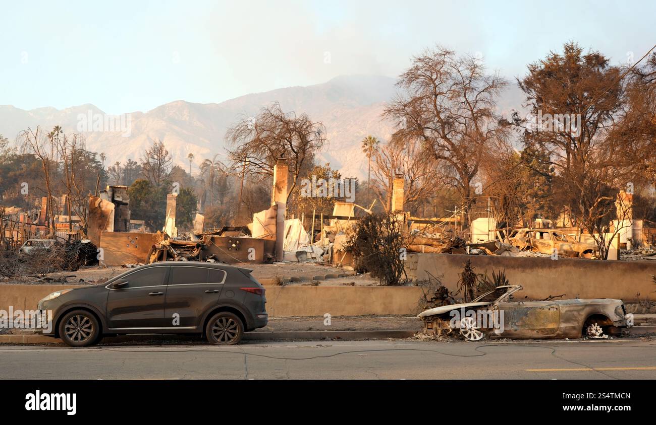 A car at right destroyed by the Eaton Fire stands next to an intact car ...