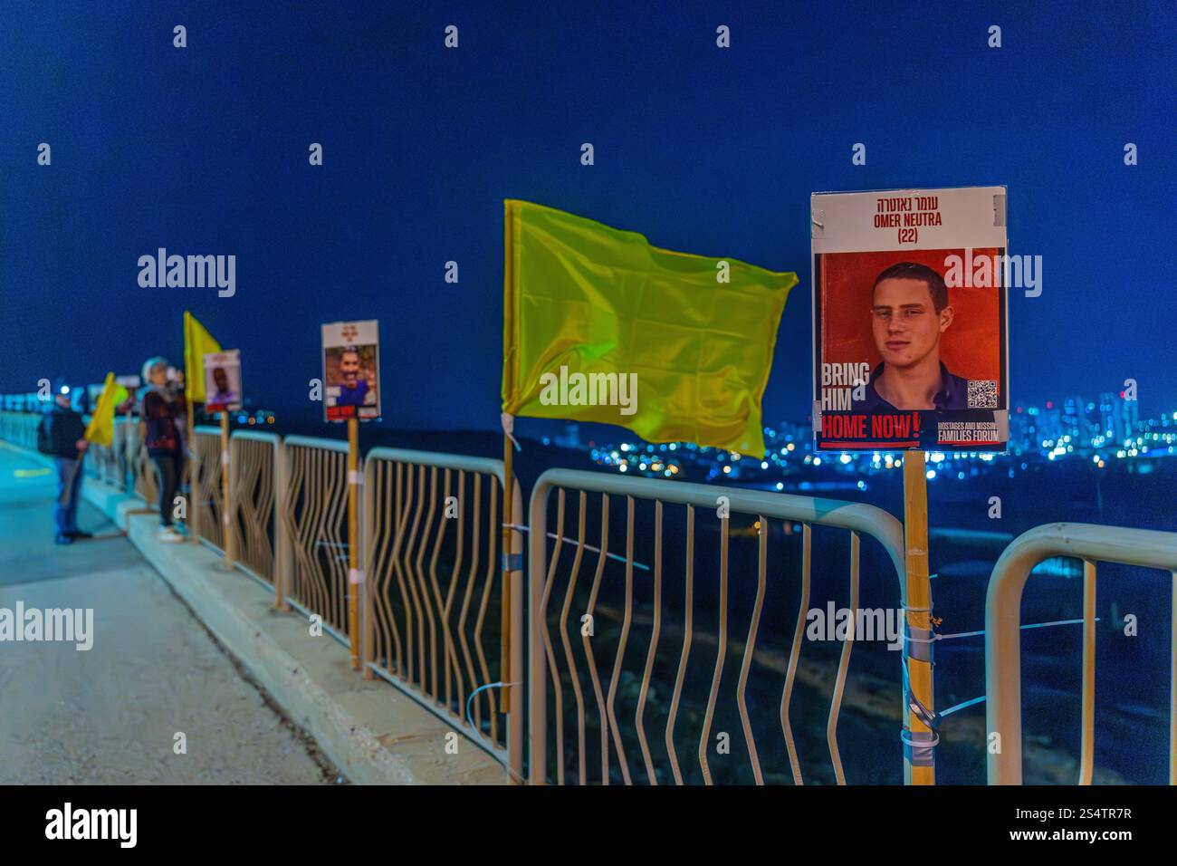 Haifa, Israel - January 12, 2025: People hang and maintain posters of ...