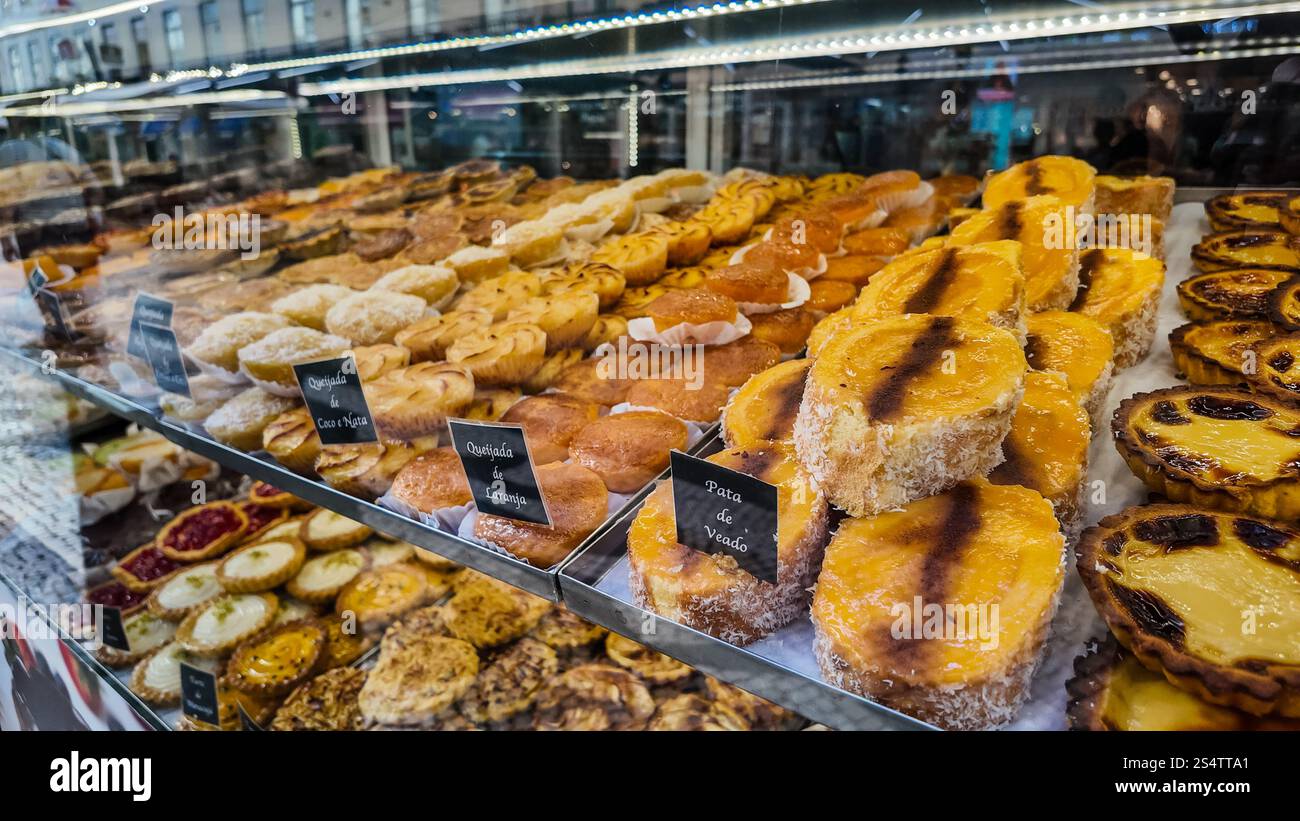 A shop window displaying a variety of baked Portuguese desserts ...
