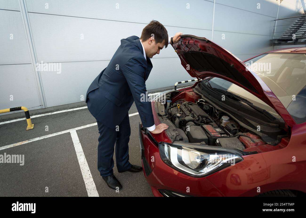 Stressed young businessman looking under the car hood Stock Photo - Alamy