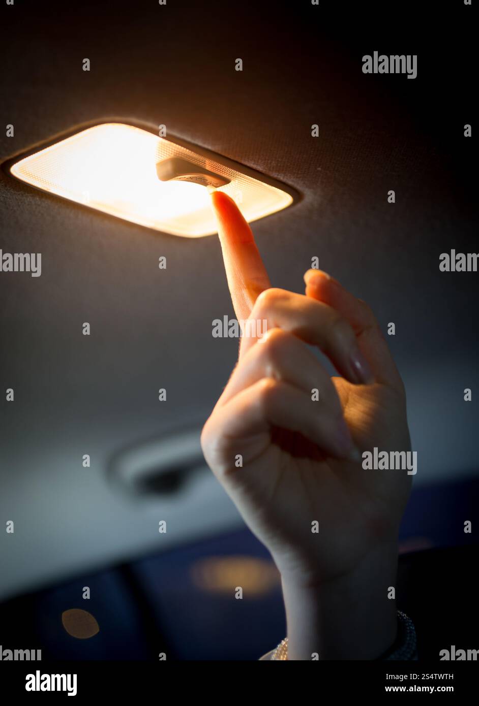 Closeup photo of woman turning light on in car salon Stock Photo - Alamy