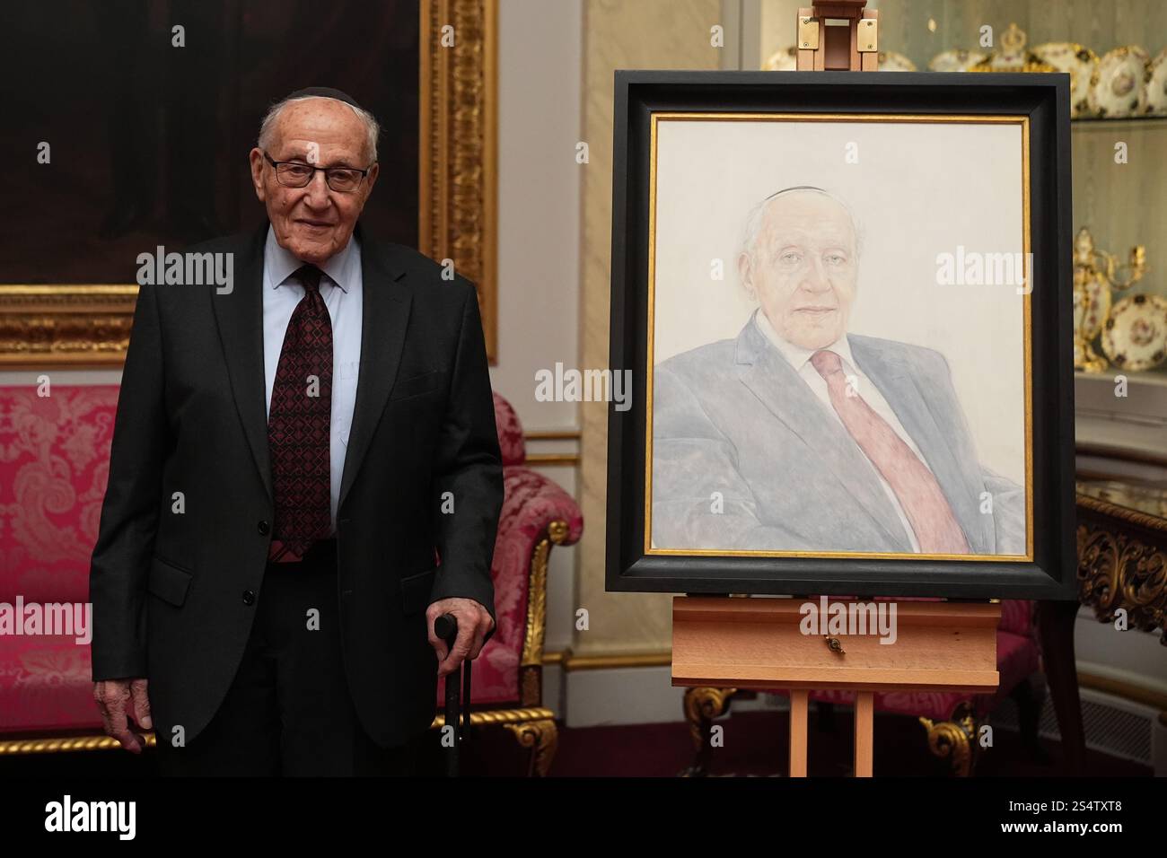 Holocaust survivor Manfred Goldberg poses beside a portrait of himself ...
