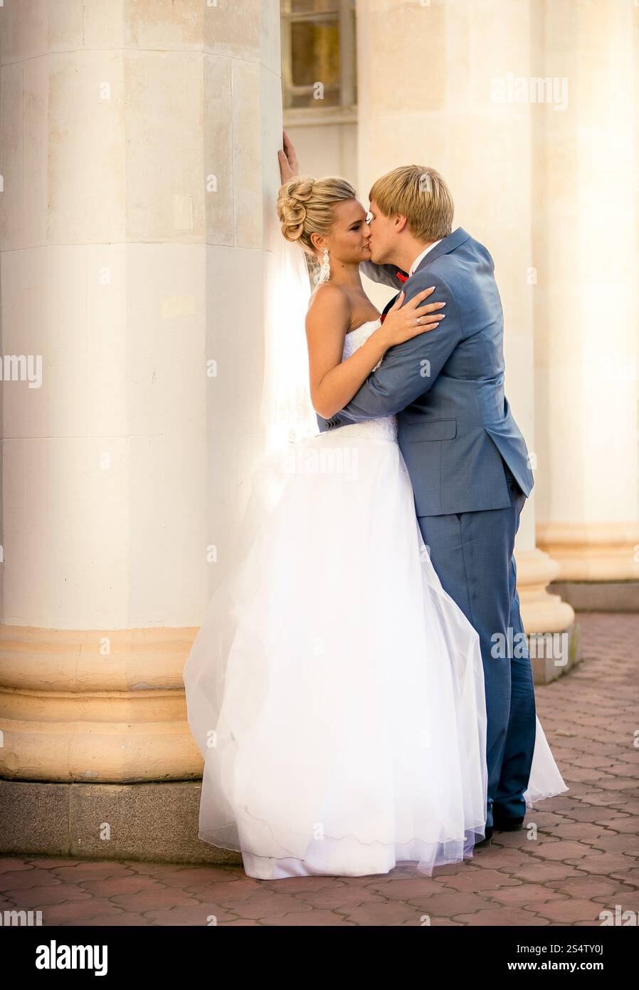 Beautiful newly married couple kissing against old column Stock Photo ...