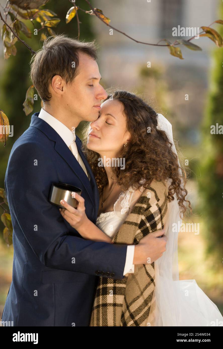 Romantic closeup portrait of bride and groom hugging at park at warm ...