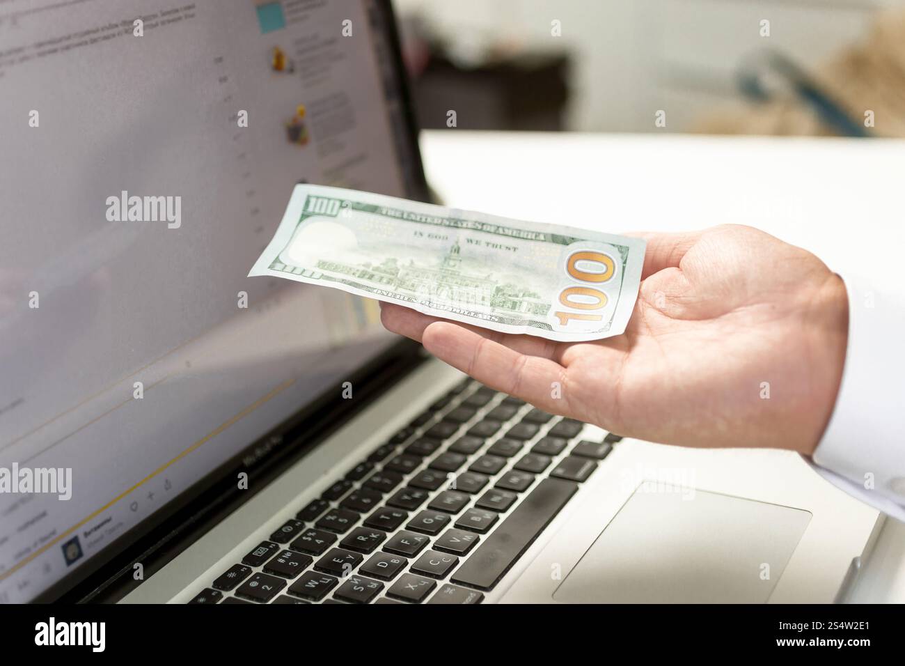 Conceptual shot of payment in internet. Man holding banknote on hand in ...