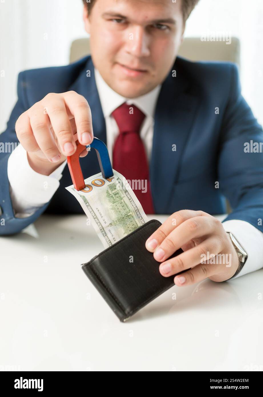 Portrait of greedy businessman pulling money out wallet with use of ...