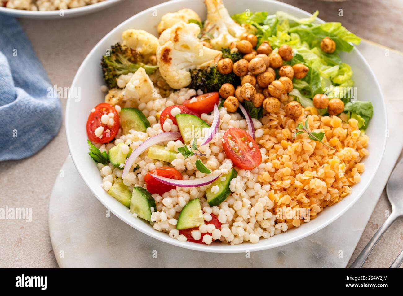 Vegan lunch bowl with lentils, roasted vegetables and chickpeas, pearl couscous salad with ...