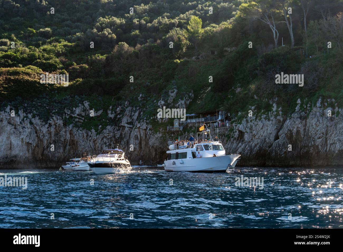 A tour boat traffic jam at the Blue Grotto on the island of Capri ...