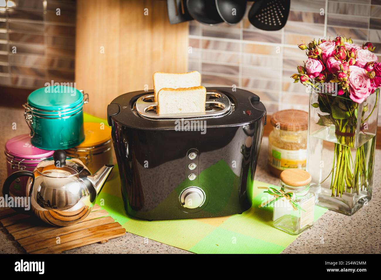 Black toaster with bread slices on kitchen table Stock Photo - Alamy