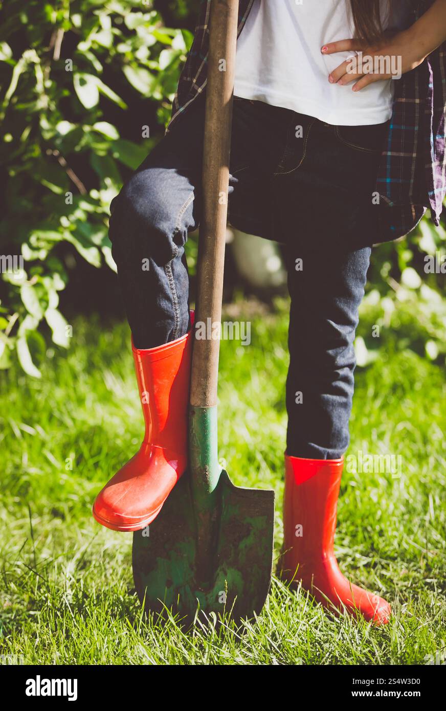 Closeup toned photo of young woman holding leg in rubber boots on ...