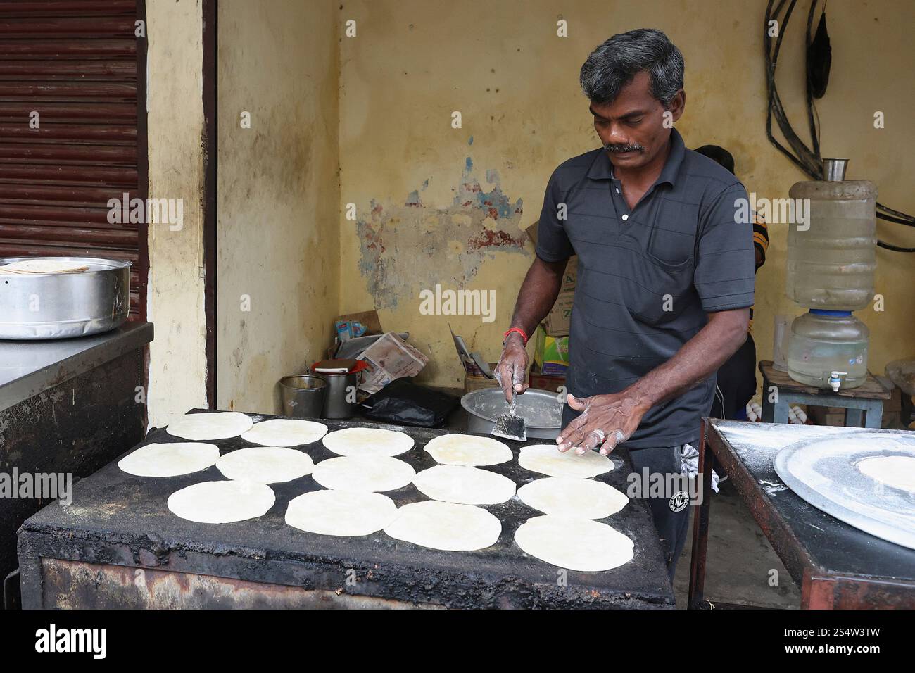 India, Tamil Nadu, Chennai, Man cooking chapati in market Stock Photo ...