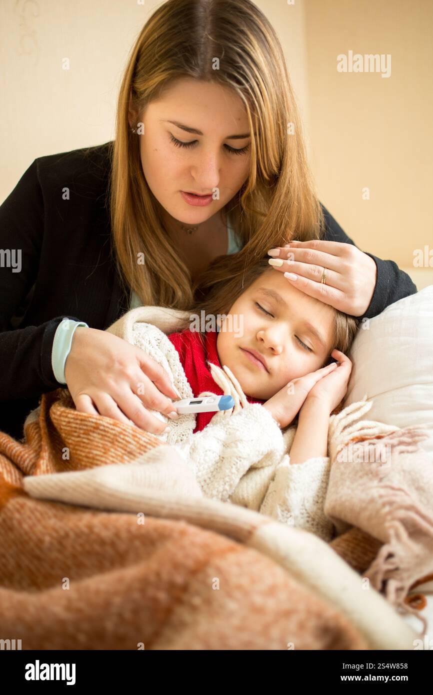 Portrait of young mother hugging sick girl in bed Stock Photo - Alamy