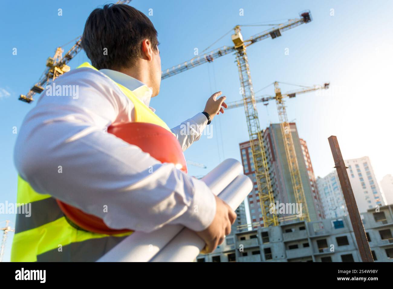 Building inspector looking up and pointing at the building under ...