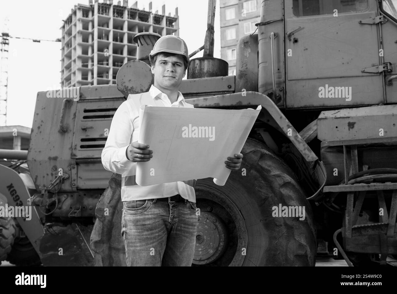 Black and white portrait of engineer reading instructions to bulldozer ...