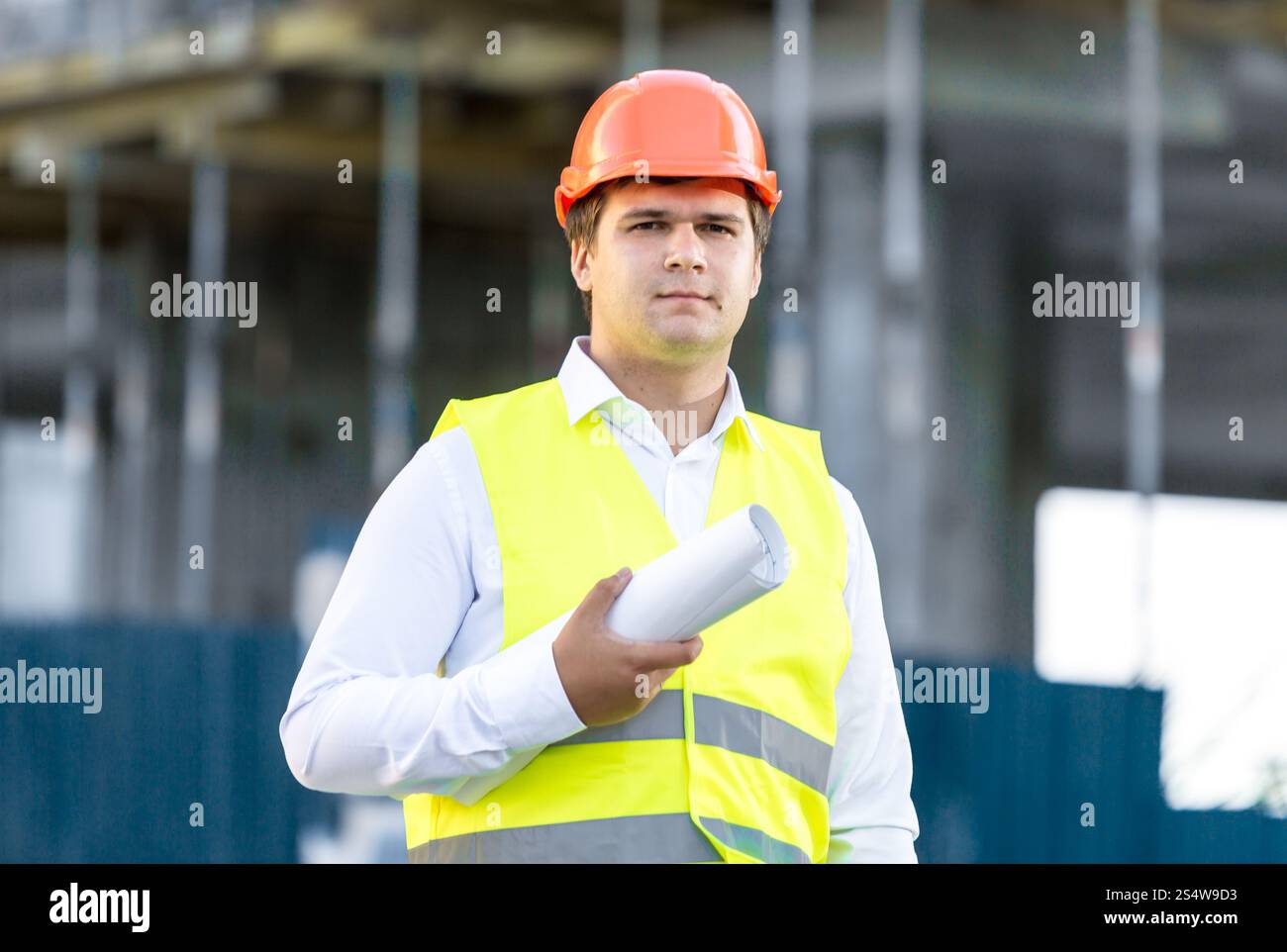 Closeup portrait of construction manager posing against scaffolding ...