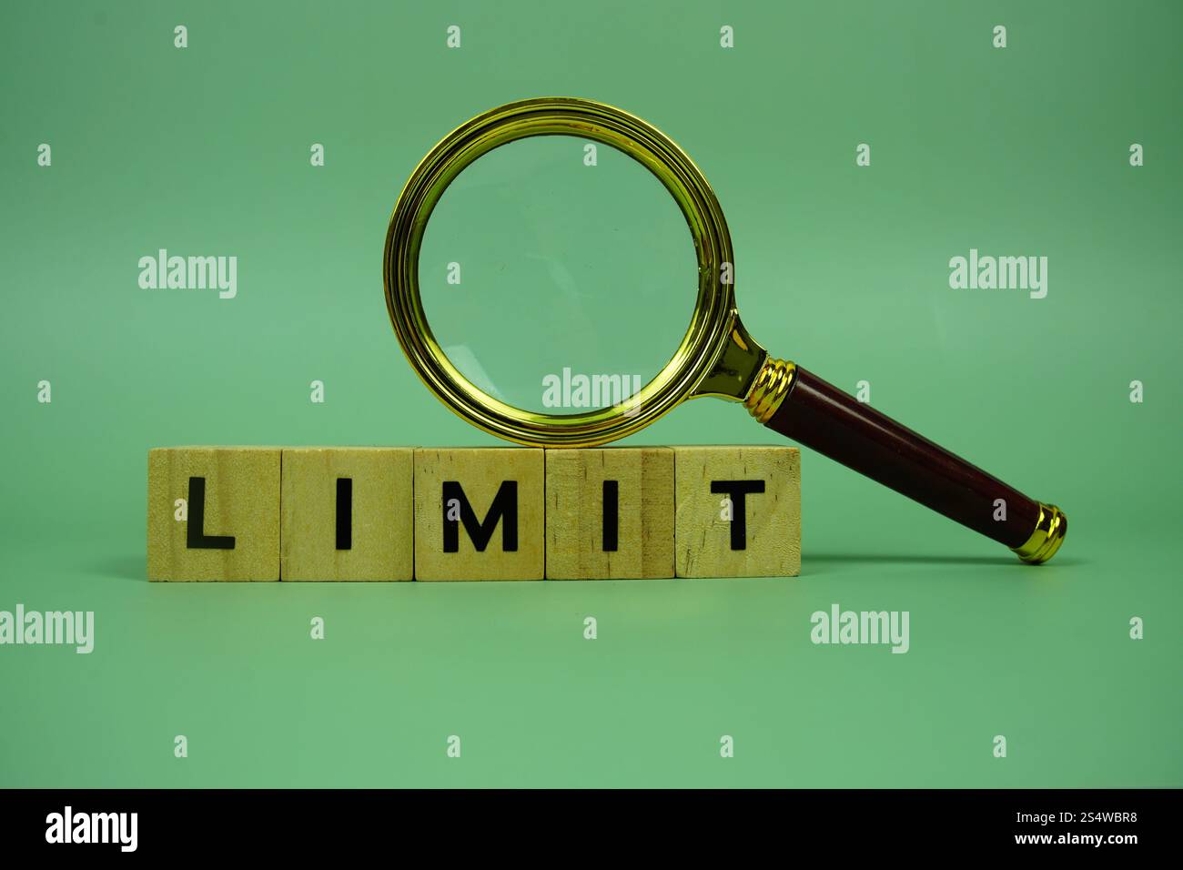 Limit with wooden blocks alphabet letters and magnifying glass on green ...