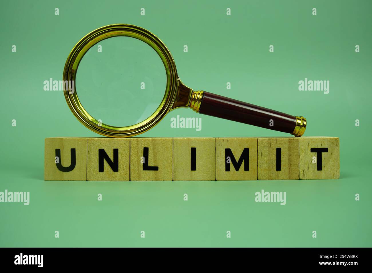 Unlimit with wooden blocks alphabet letters and magnifying glass on ...