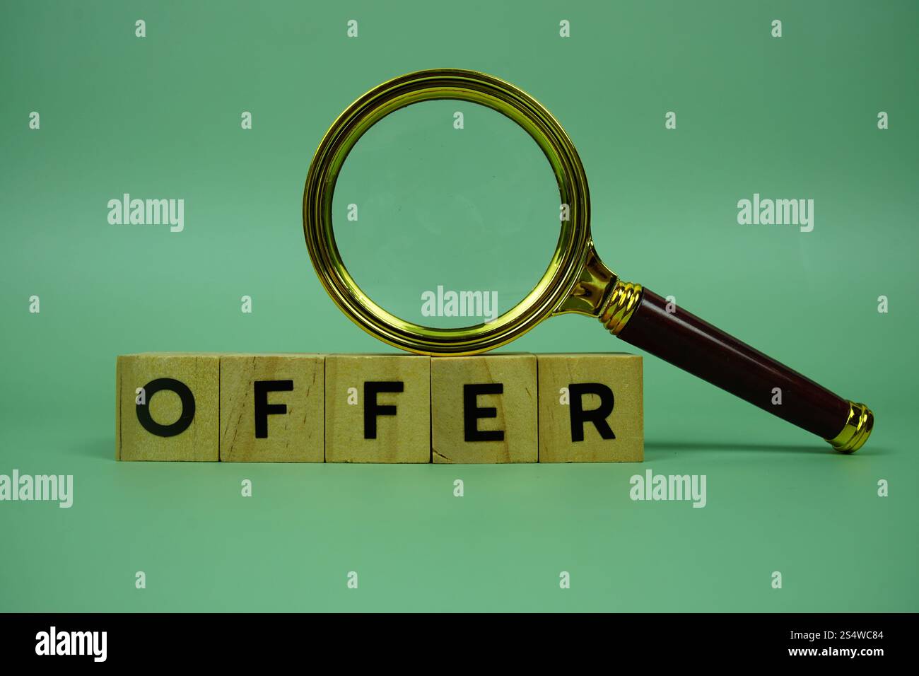 Offer with wooden blocks alphabet letters and magnifying glass on green ...