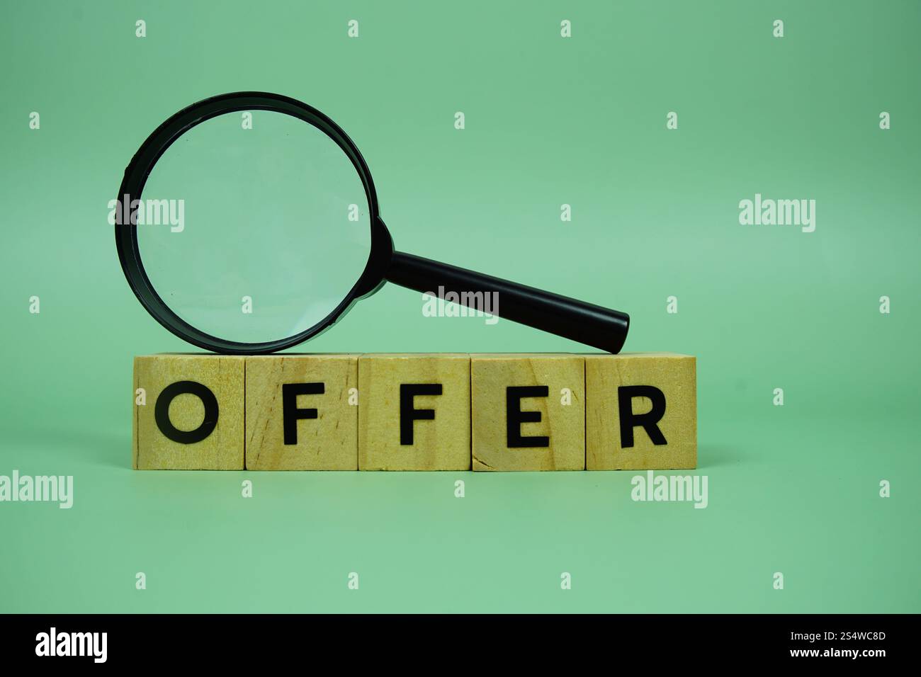Offer with wooden blocks alphabet letters and magnifying glass on green ...
