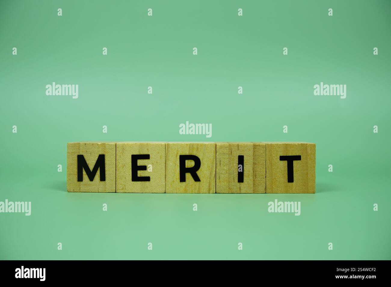 Merit with wooden blocks alphabet letters on green background Stock ...