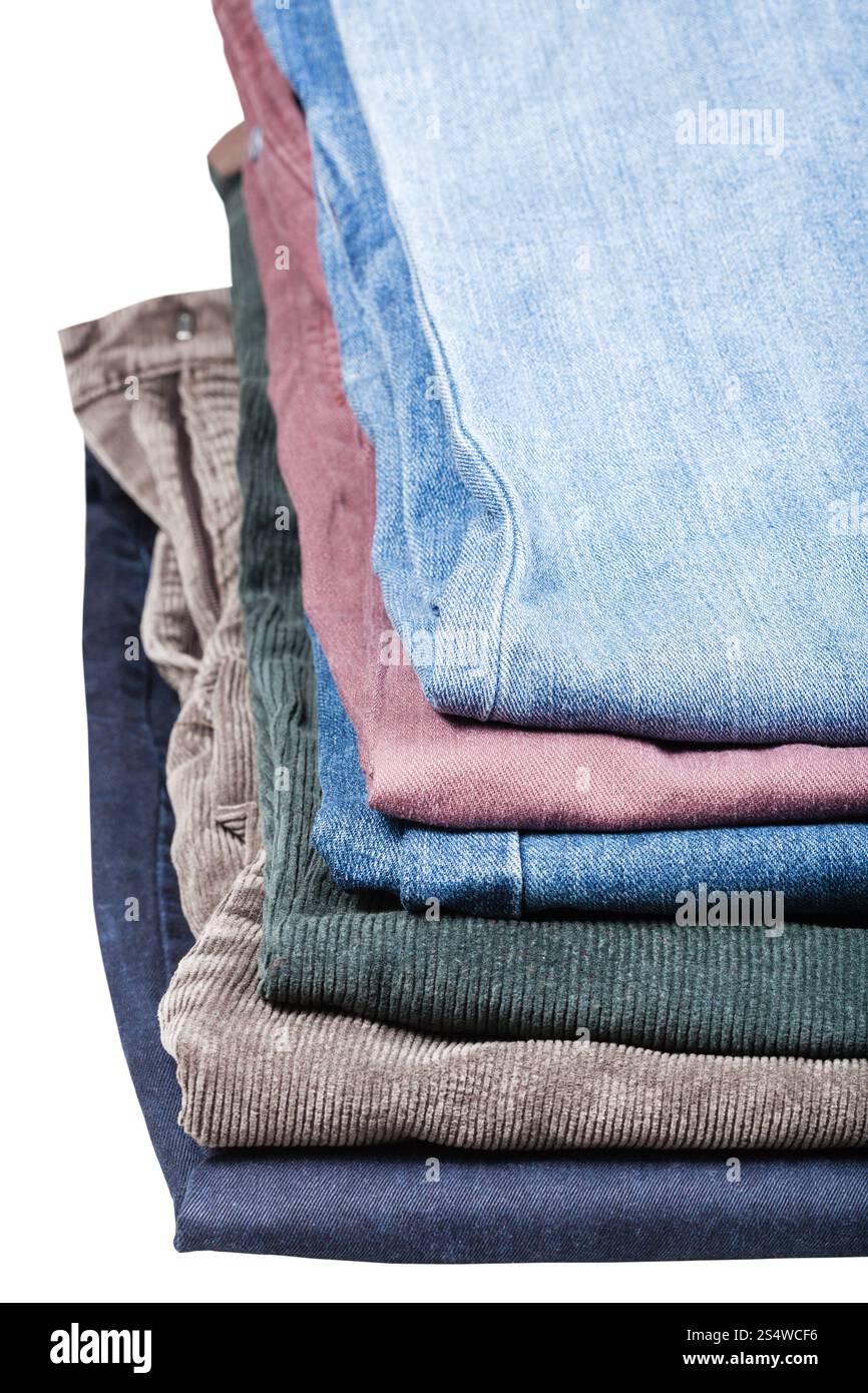 stack of various jeans and corduroys close up isolated on white ...