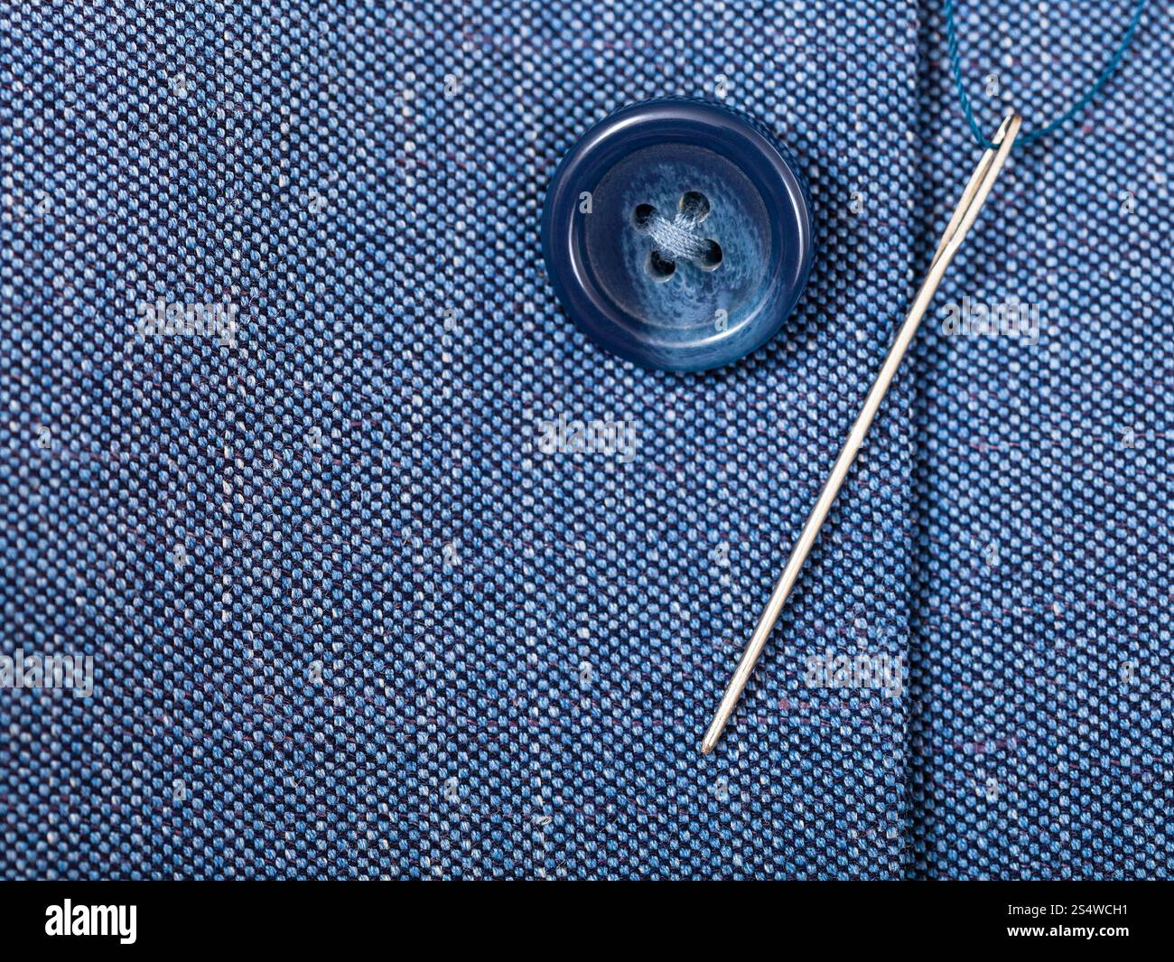 attaching of button to blue silk tissue by needle close up Stock Photo ...