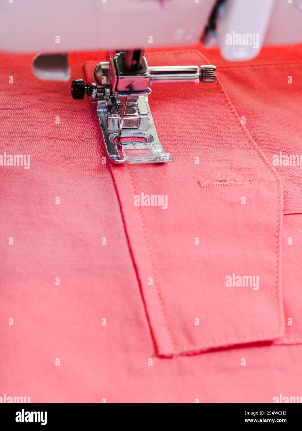attaching pocket to red blouse on sewing machine close up Stock Photo ...