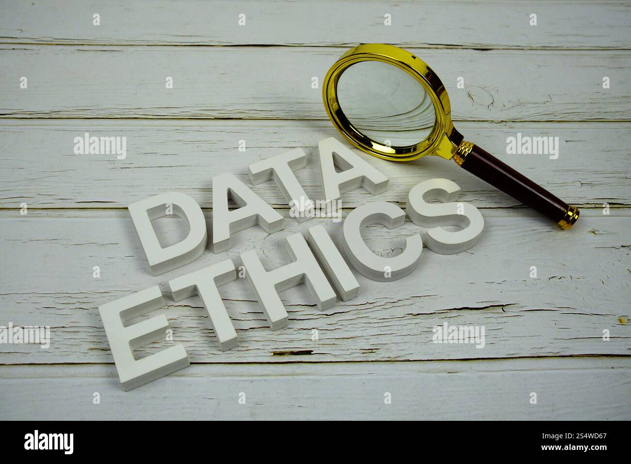 Data ethics alphabet letters and magnifying glass top view on wooden ...