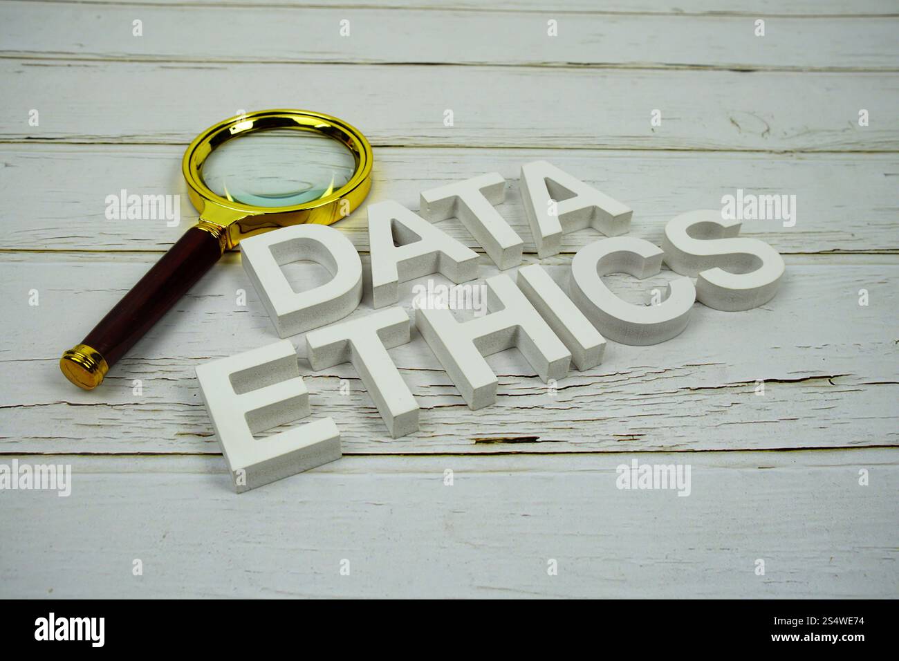 Data Ethics alphabet letters and magnifying glass top view on wooden ...