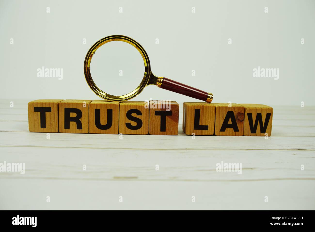 Trust Law with wooden blocks alphabet letters and magnifying glass on ...