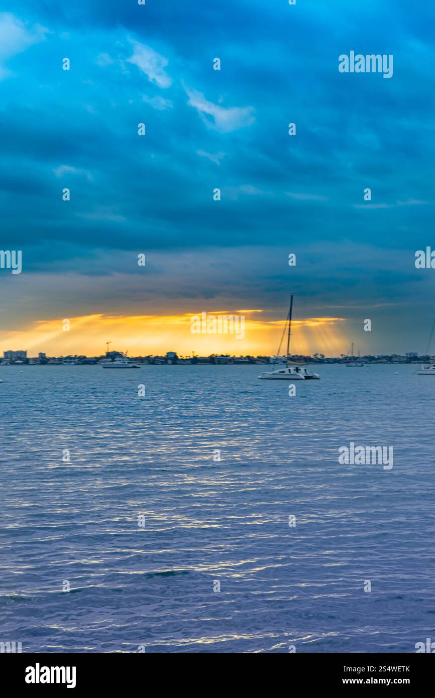 A beautiful sunset at Bayfront Park, Sarasota, Florida, features a vibrant sky with blue, puffy ...