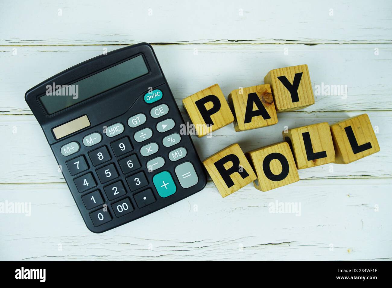 Payroll alphabet letters with calculator top view on wooden background ...